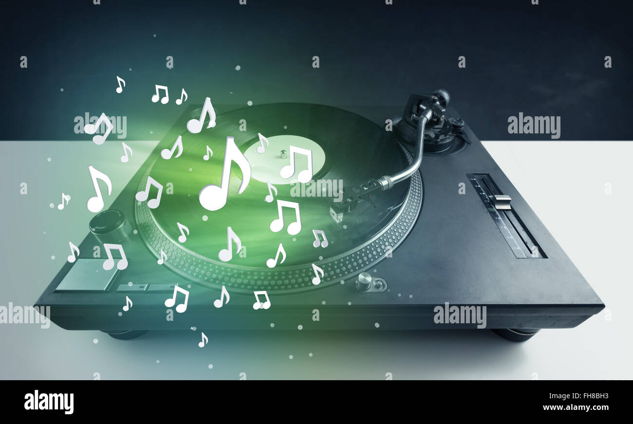Turntable playing music with audio notes glowing Stock Photo - Alamy