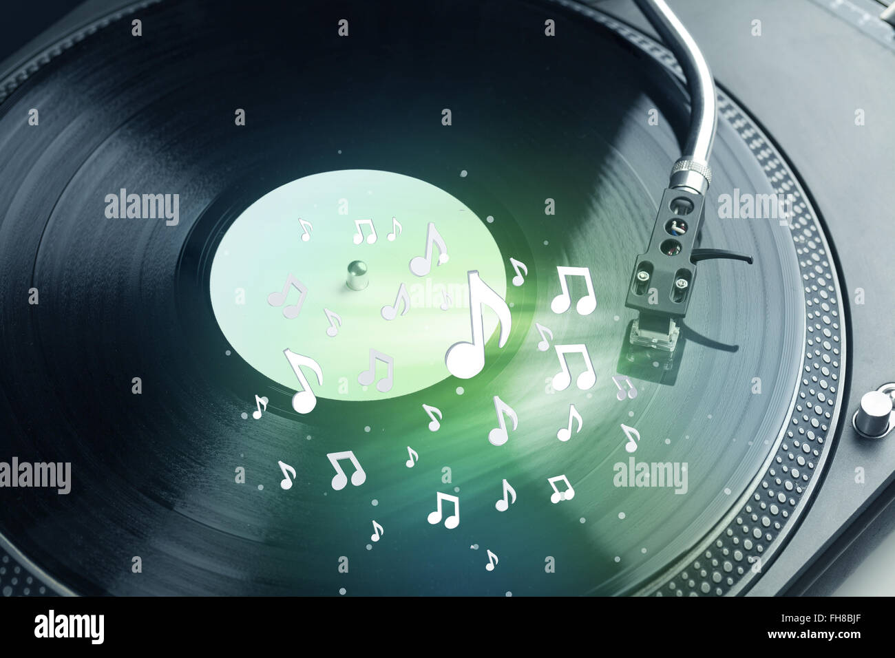 Turntable playing music with audio notes glowing Stock Photo - Alamy