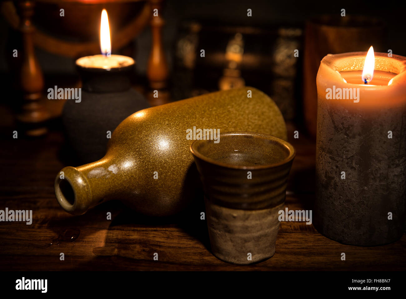 beautiful medieval background with a old bottle, a mug and candles ...