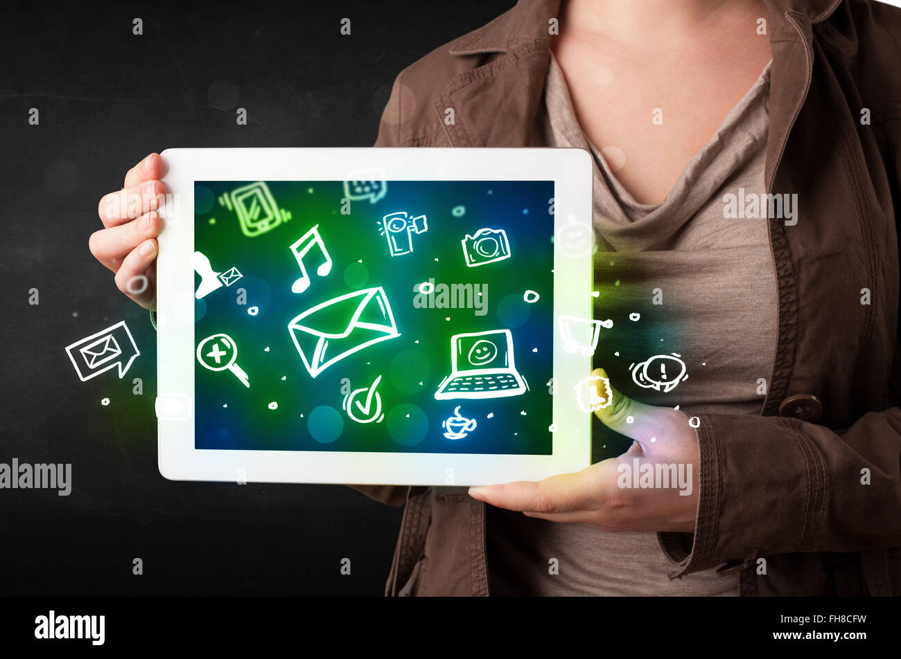 Person holding a tablet with media icons and symbols Stock Photo - Alamy