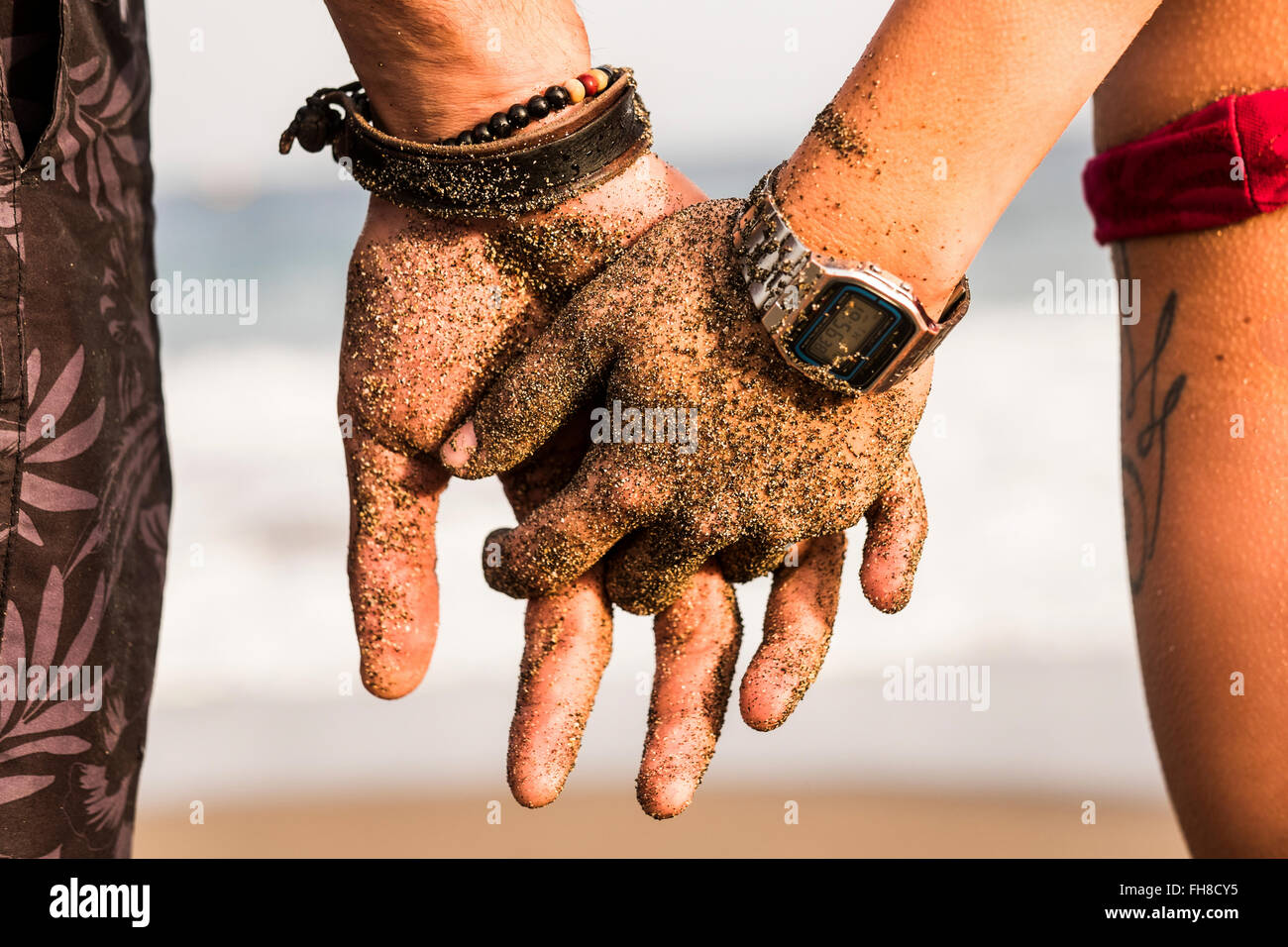 Close-up of couple holding sandy hands Stock Photo - Alamy