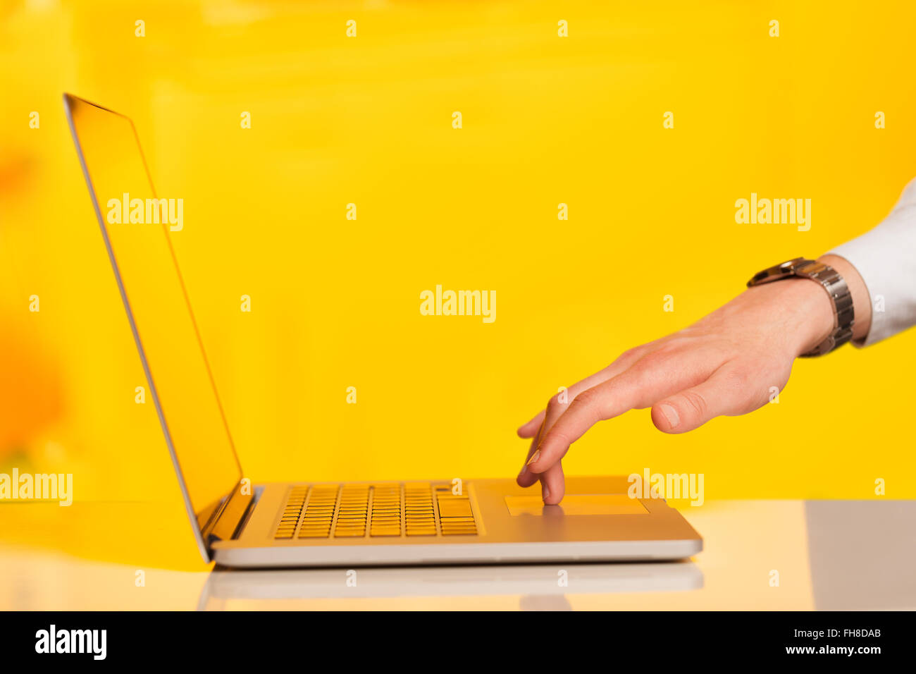 Businessman pressing modern laptop computer on colorful background ...