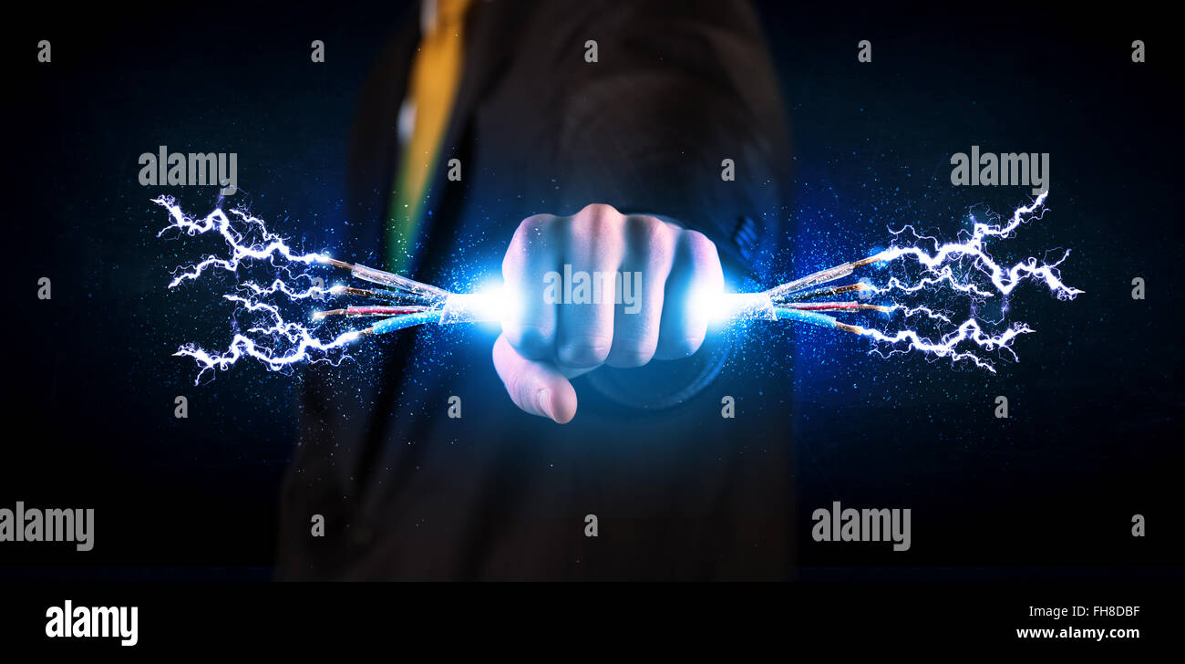 Business person holding electrical powered wires Stock Photo - Alamy