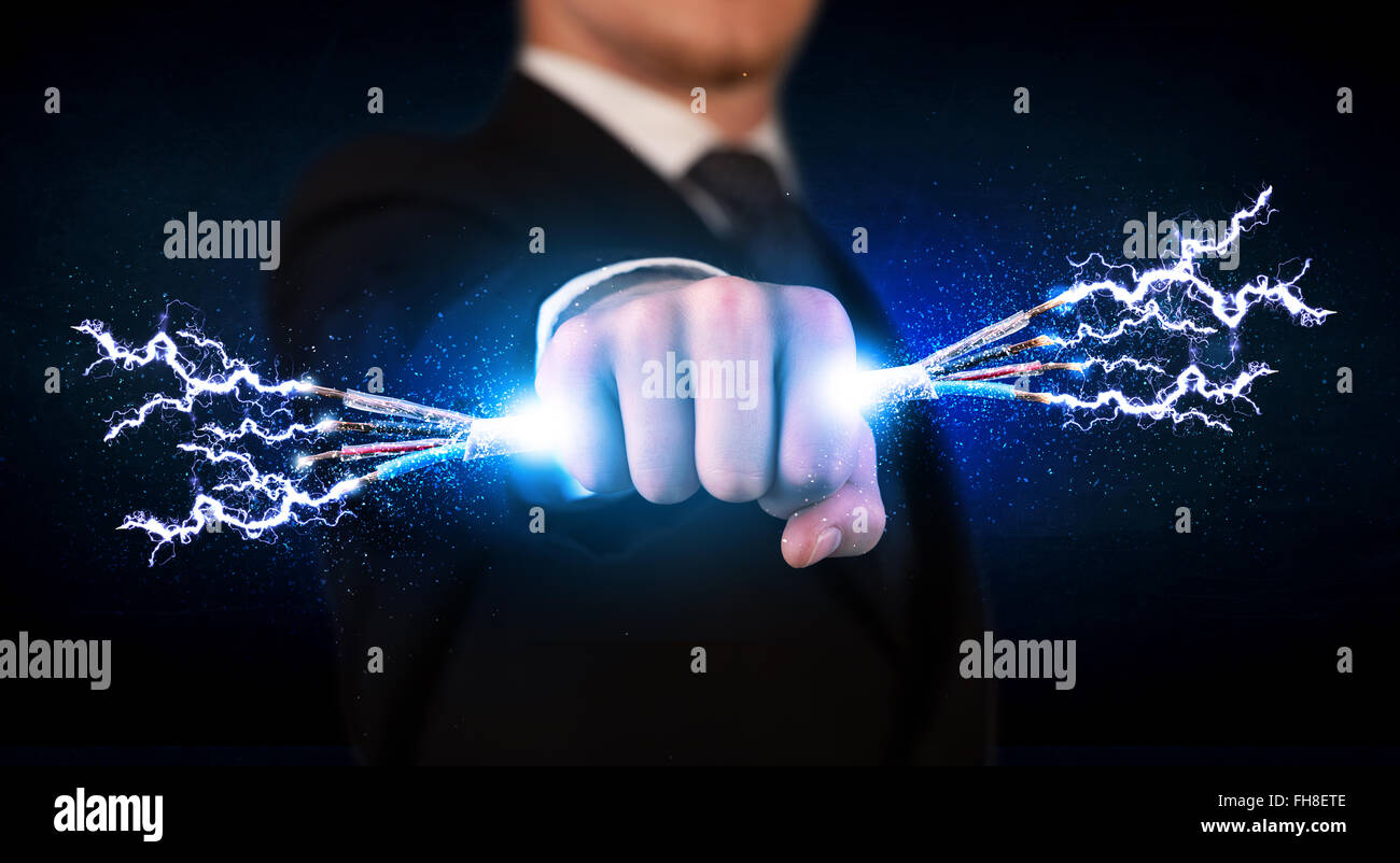 Business person holding electrical powered wires Stock Photo - Alamy