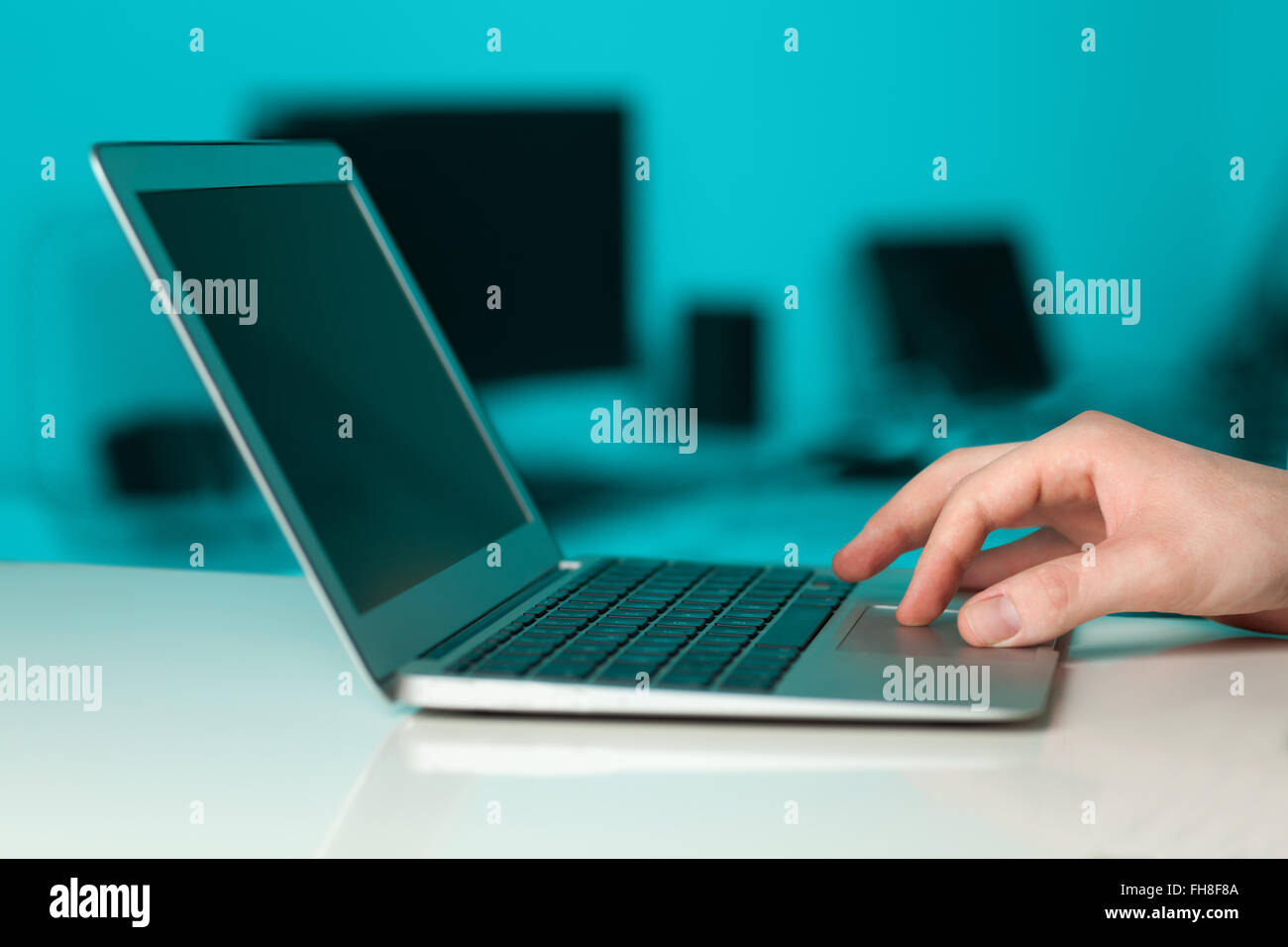 Businessman pressing modern laptop computer on colorful background ...