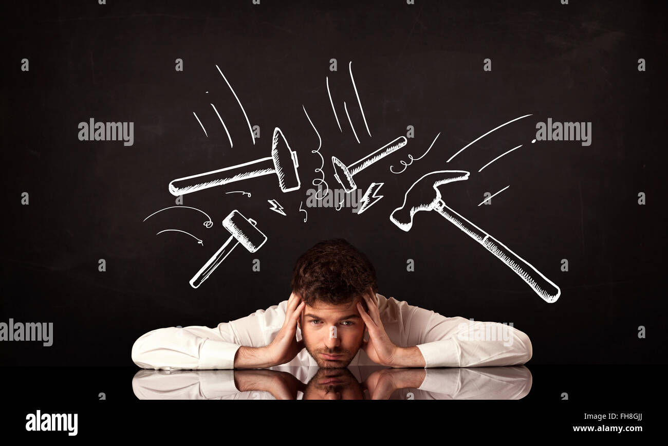 Depressed businessman sitting under hammer marks Stock Photo - Alamy