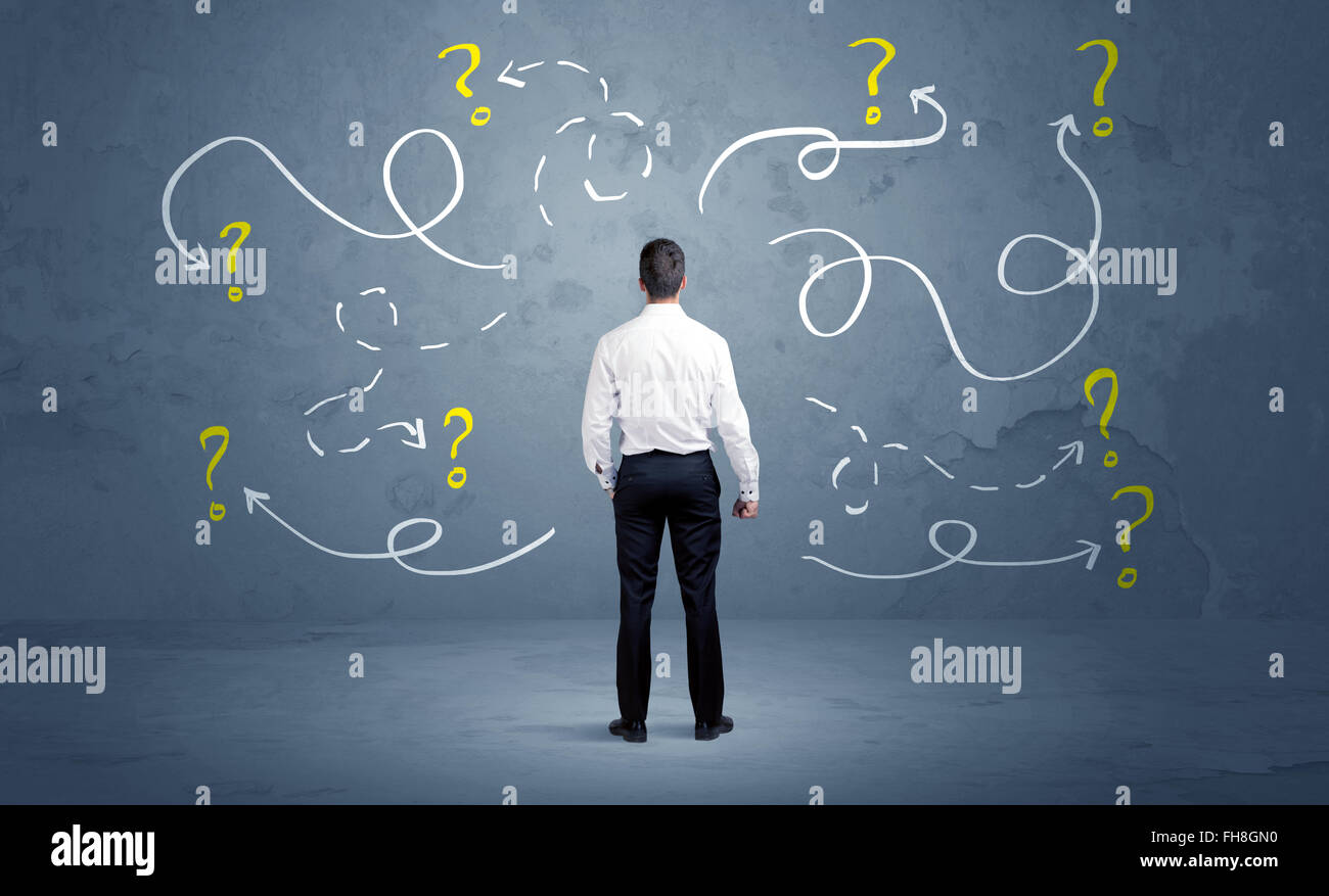Unsure businessman with question marks Stock Photo - Alamy