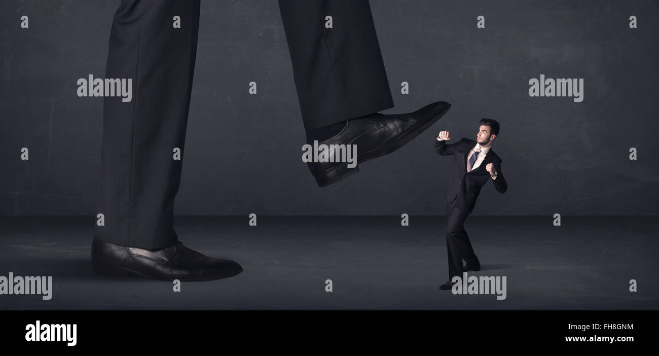 Giant person stepping on a little businessman concept Stock Photo - Alamy