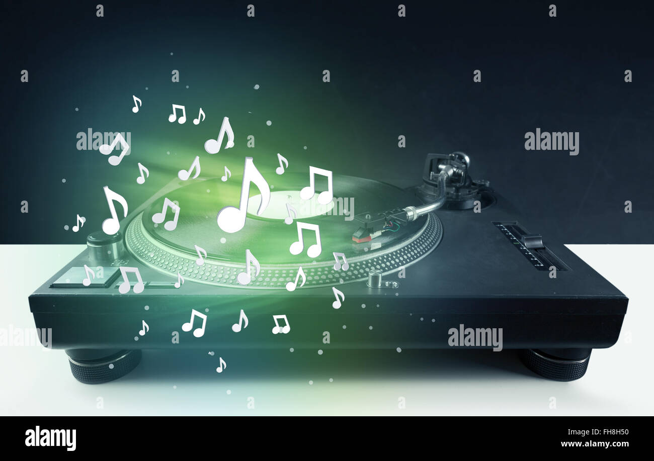Turntable playing music with audio notes glowing Stock Photo - Alamy