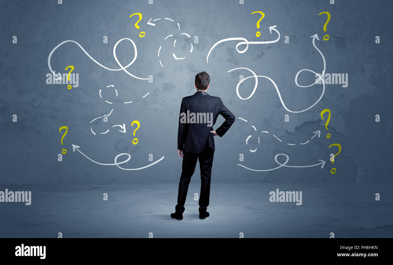 Unsure businessman with question marks Stock Photo - Alamy