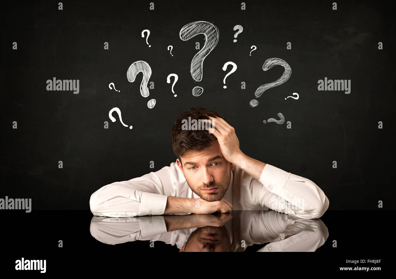 Sitting businessman under question marks Stock Photo - Alamy
