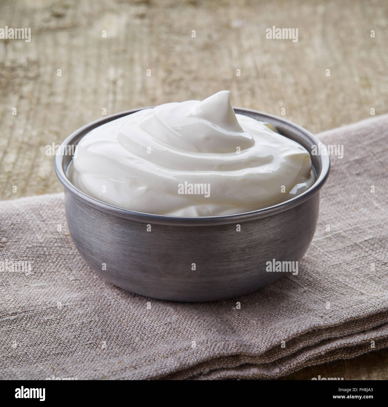 Metallic bowl of cream on wooden table Stock Photo - Alamy
