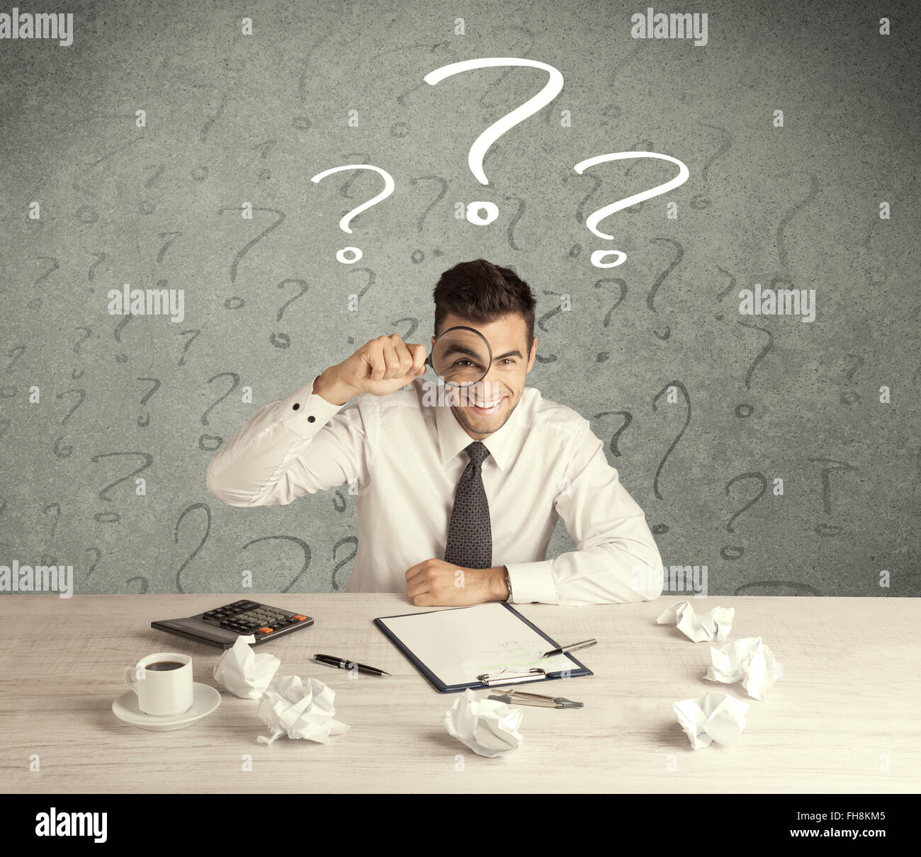Businessman at desk with question mark Stock Photo - Alamy