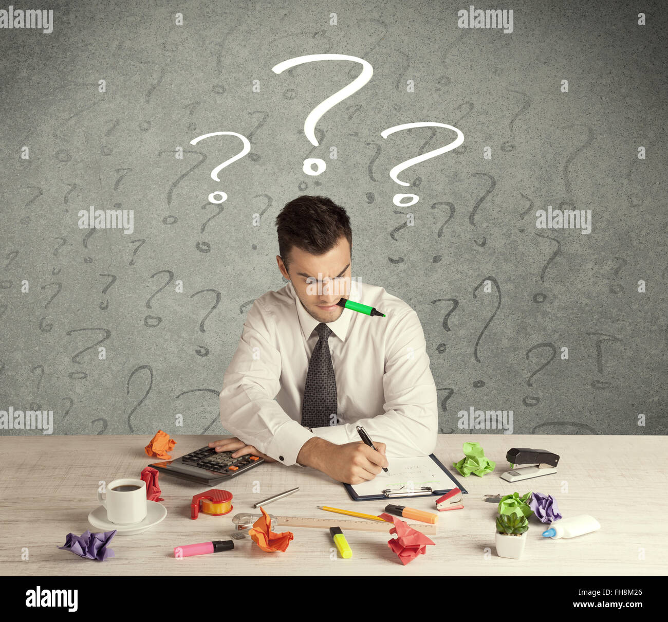 Businessman at desk with question mark Stock Photo - Alamy