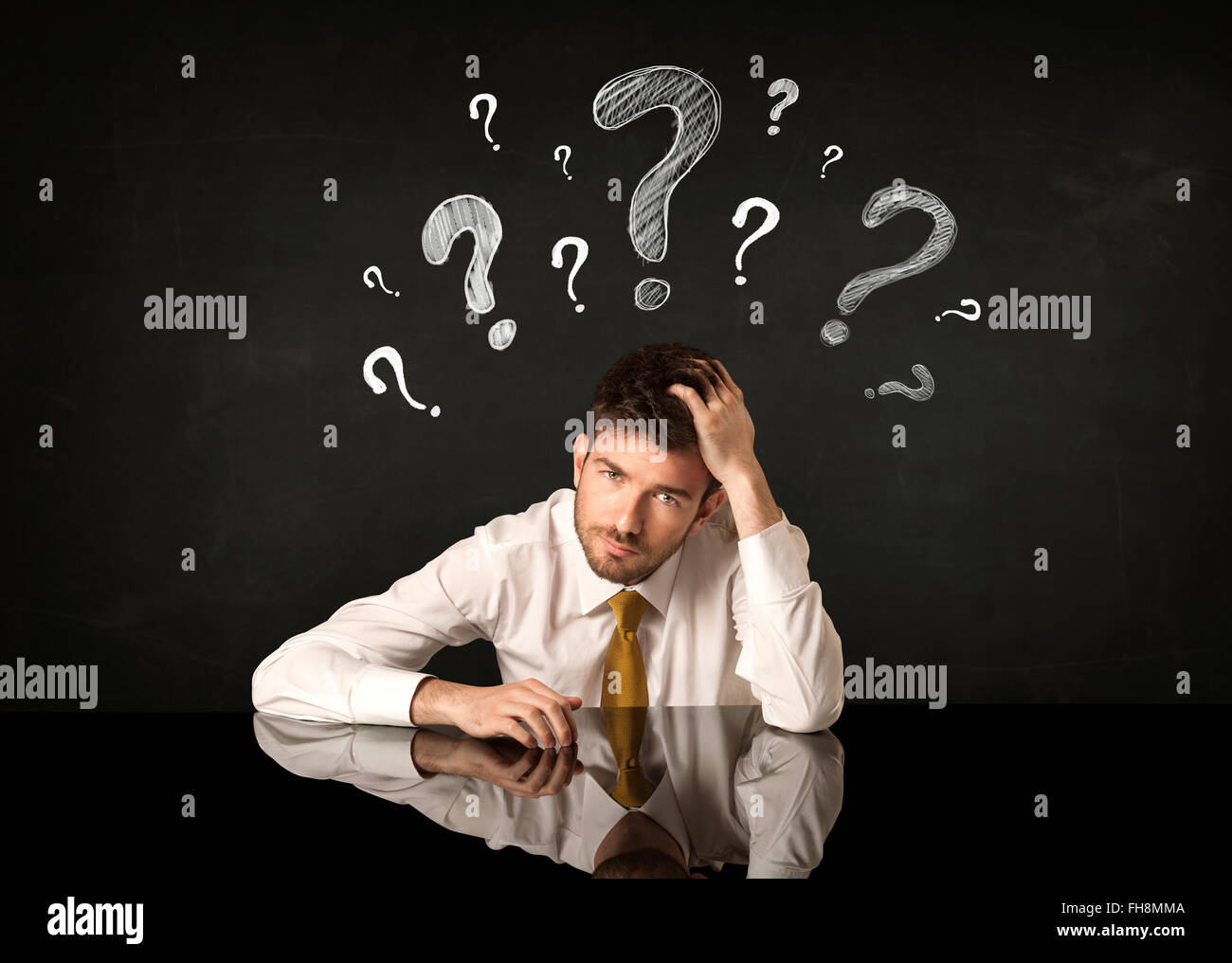 Sitting businessman under question marks Stock Photo - Alamy