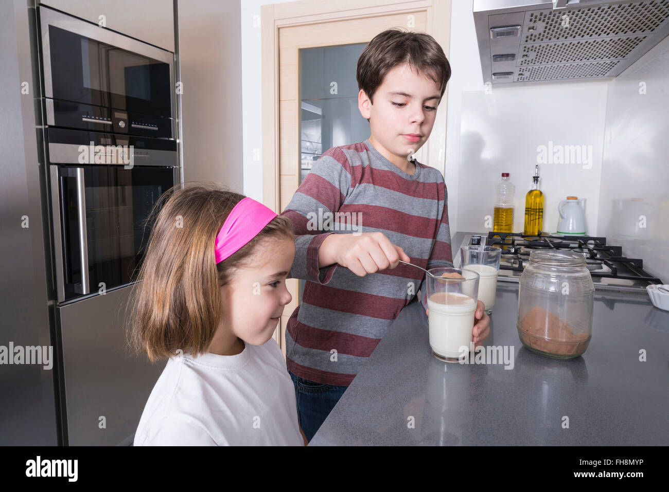 Children getting ready a glass of chocolate milk Stock Photo - Alamy