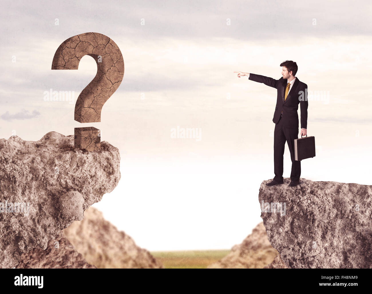 Businessman on rock mountain with a question mark Stock Photo - Alamy