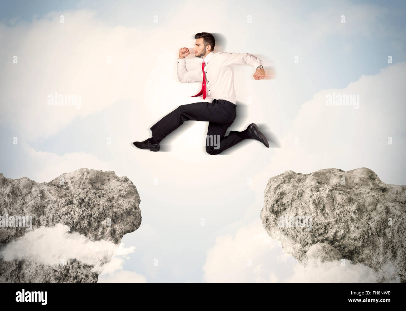 Happy business man jumping over a cliff Stock Photo - Alamy