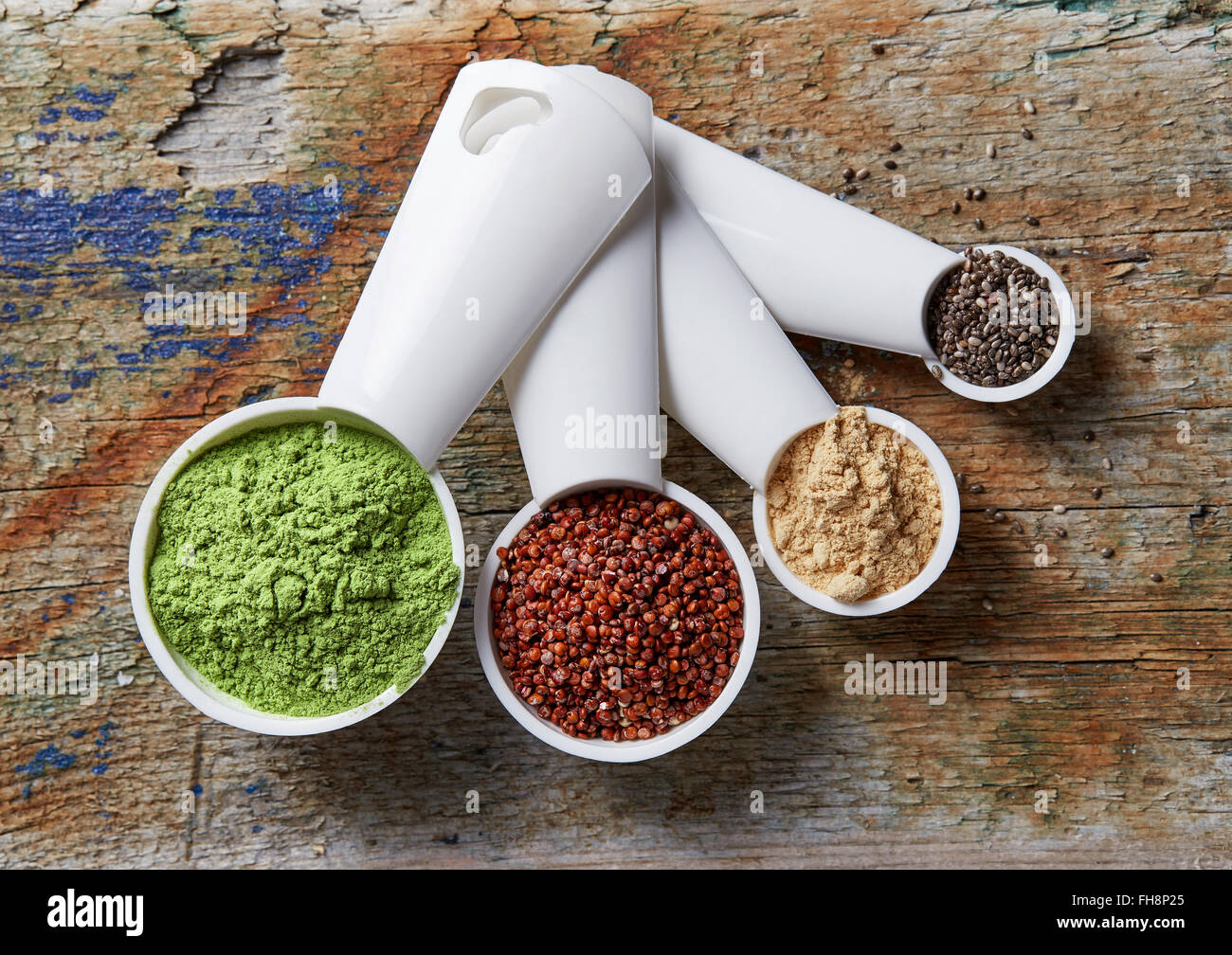 Measuring scoops with barley or wheat grass powder, red quinoa, maca ...