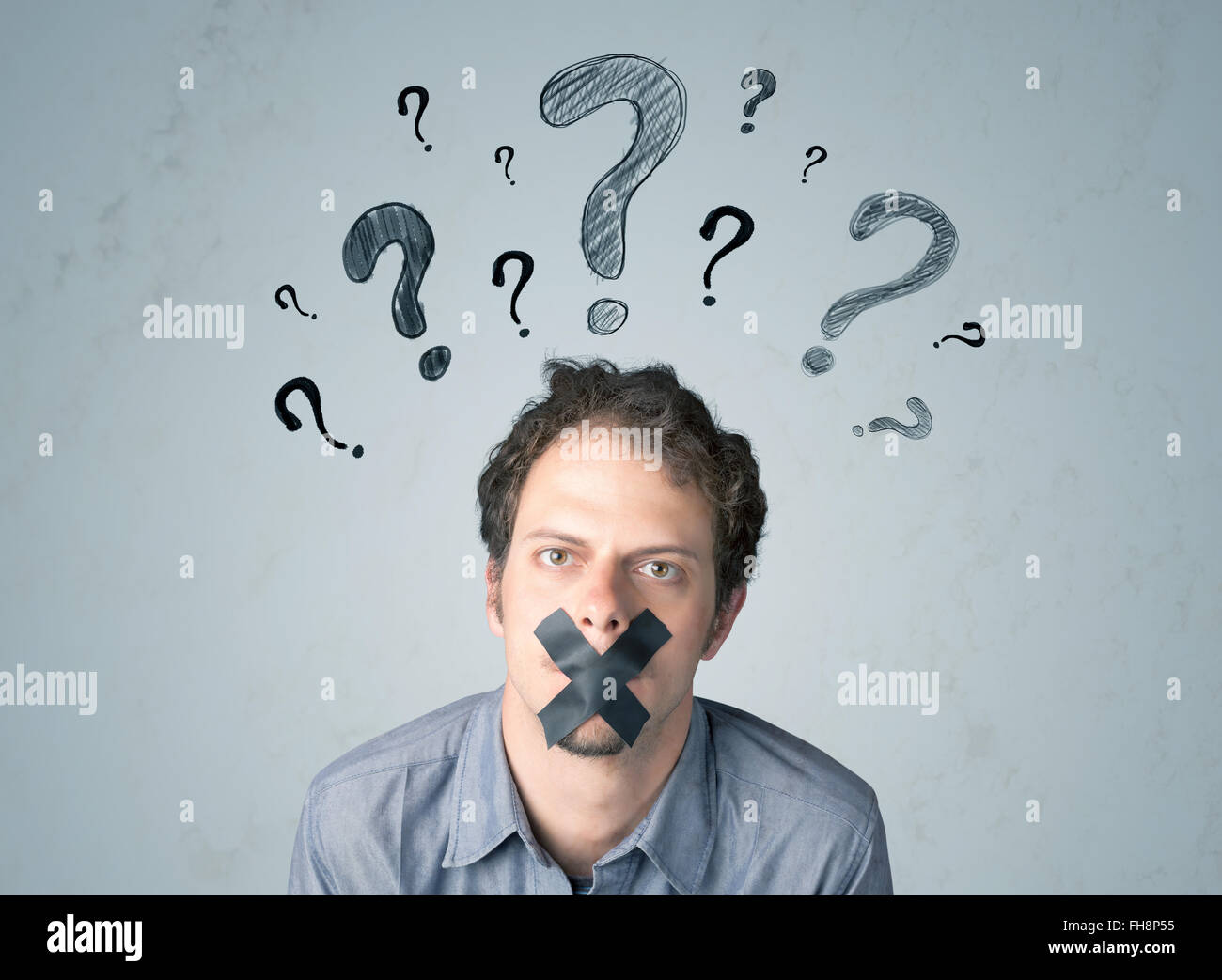 Young man with glued mouth and question mark symbols Stock Photo - Alamy