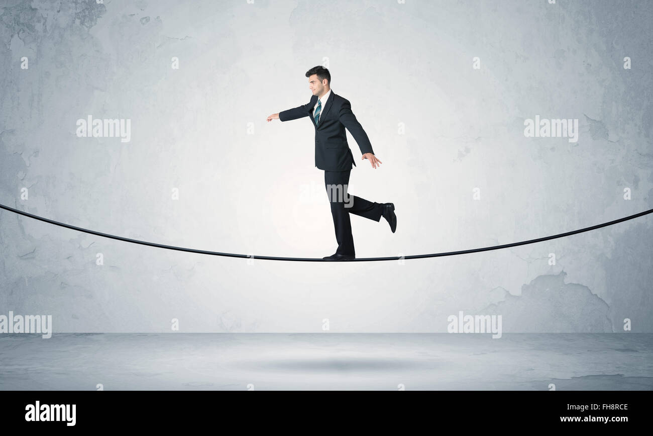 Sales guy balancing on tight rope Stock Photo - Alamy