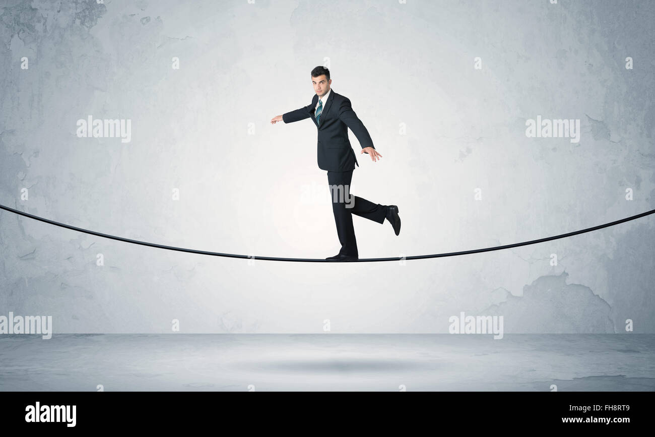 Sales guy balancing on tight rope Stock Photo - Alamy