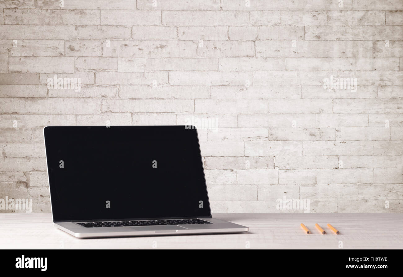 Business laptop with white brick wall Stock Photo - Alamy
