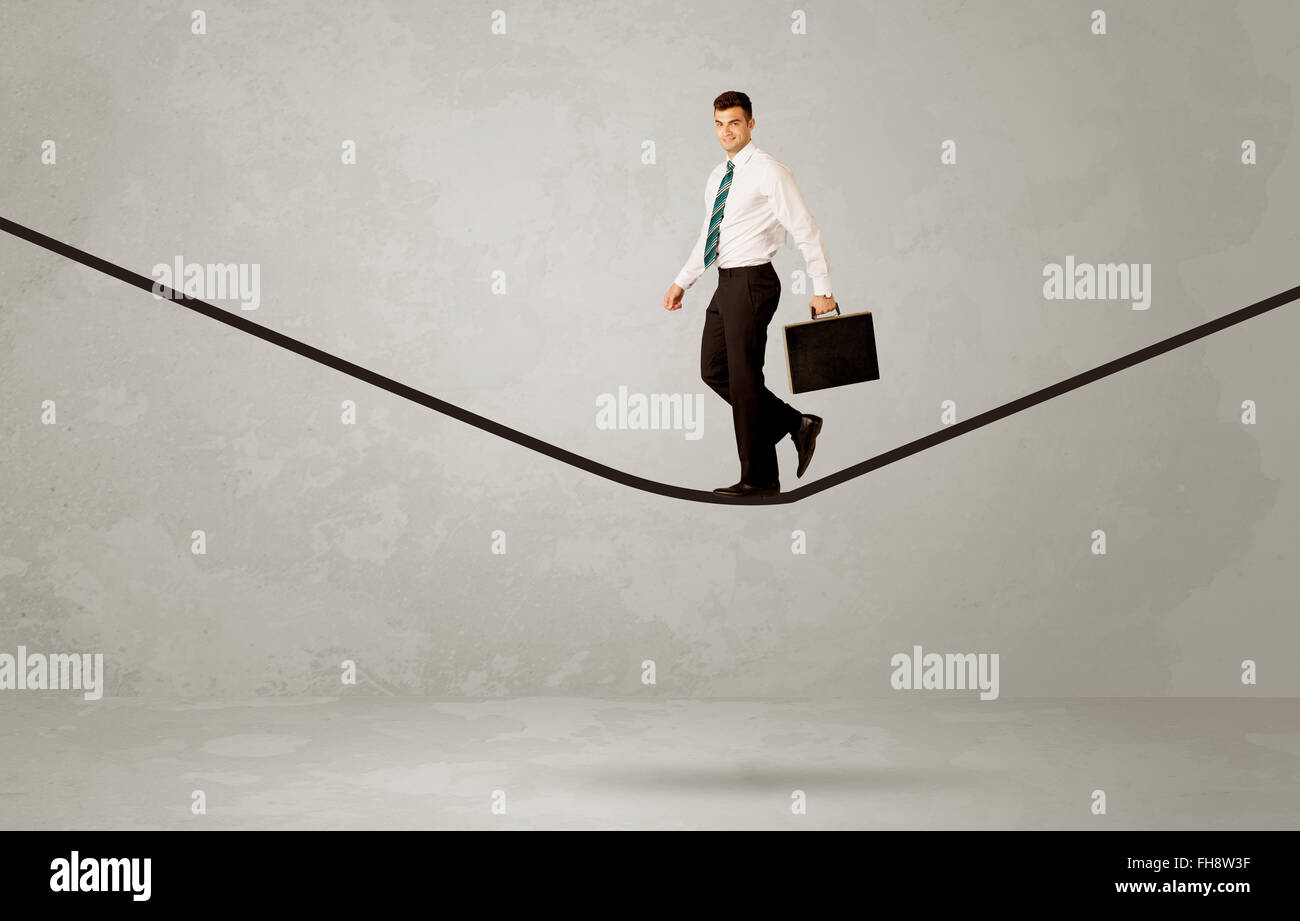 Salesman walking on rope in grey space Stock Photo - Alamy