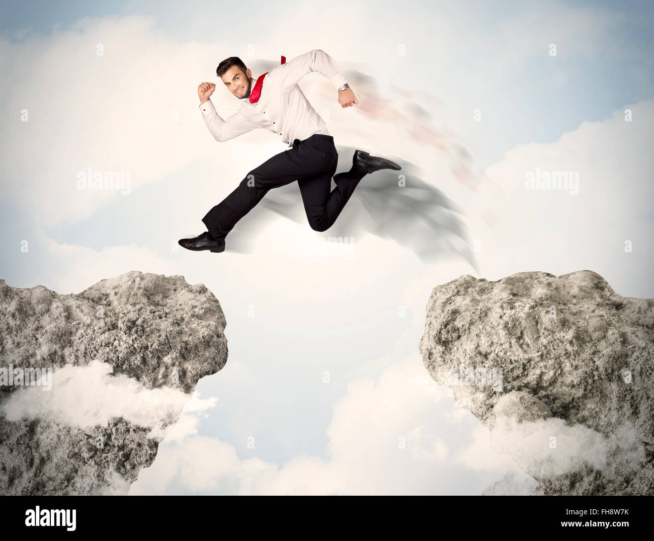 Happy business man jumping over a cliff Stock Photo - Alamy