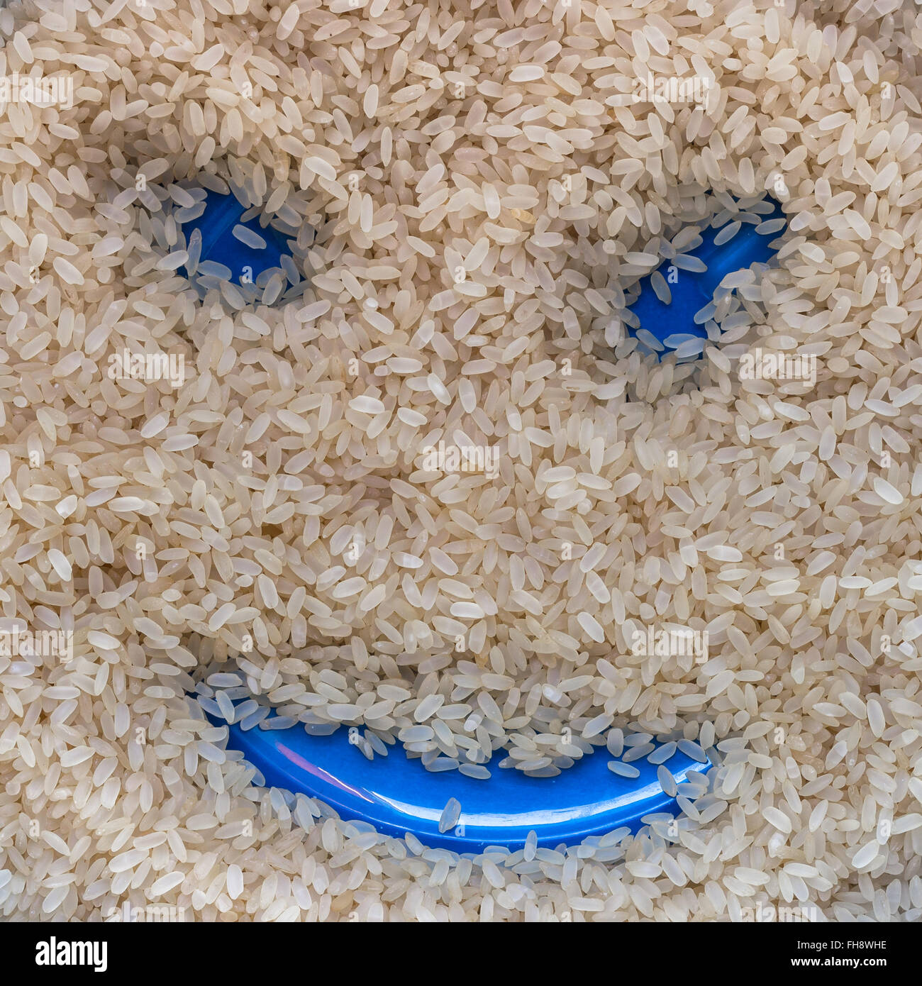 Rice grains form of smile on a blue background Stock Photo - Alamy