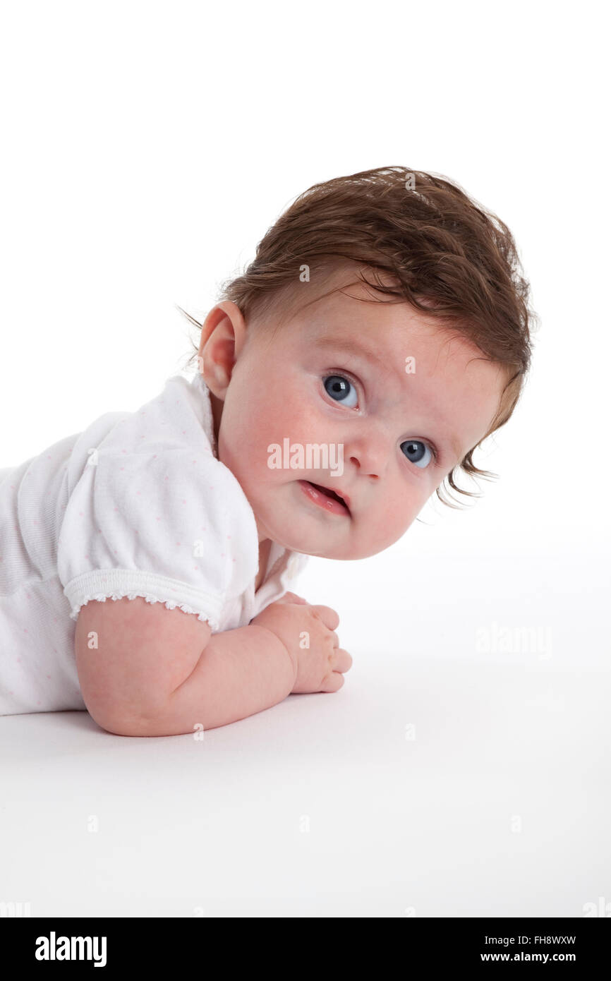Baby girl lying on her belly on white background Stock Photo - Alamy