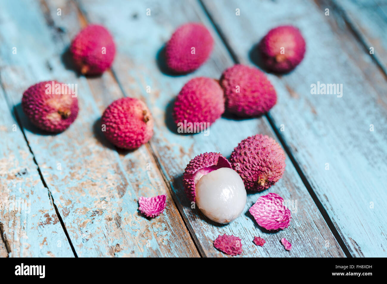Whole and peeled lychee on lightblue wood Stock Photo - Alamy