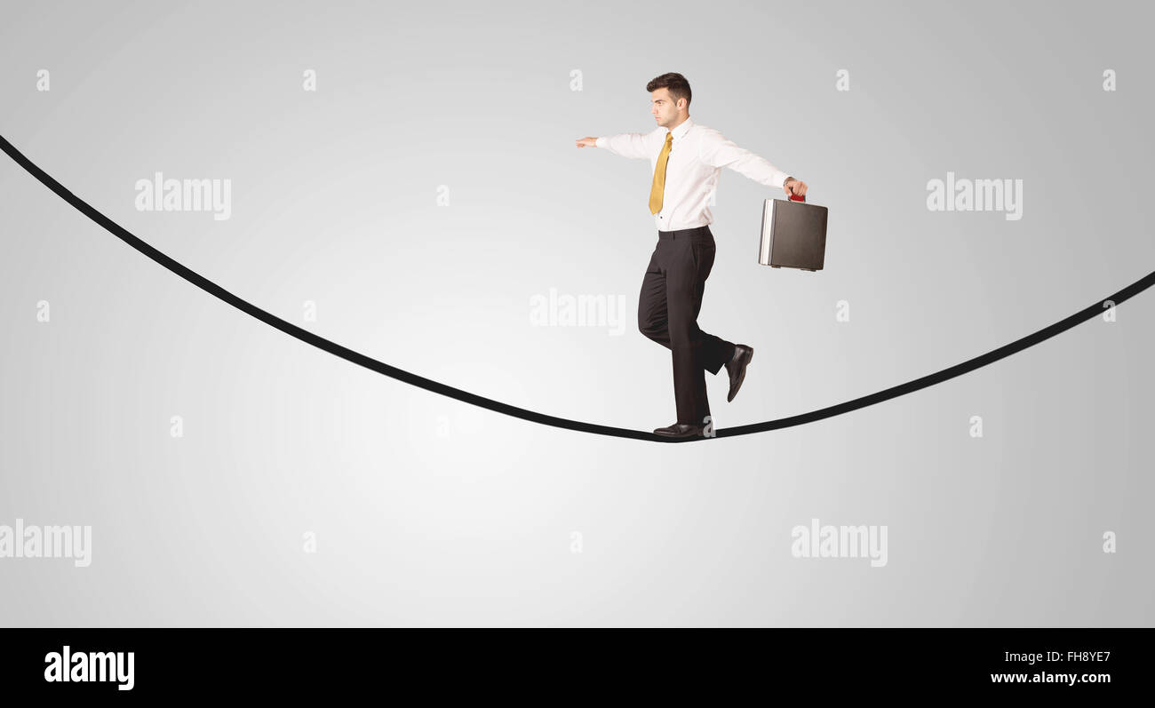 Happy businessman walking on rope Stock Photo - Alamy