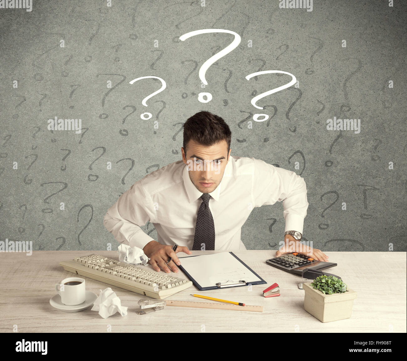 Businessman at desk with question mark Stock Photo - Alamy