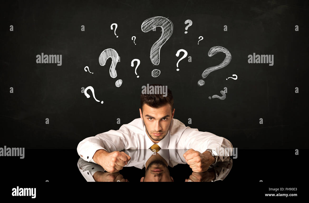 Sitting businessman under question marks Stock Photo - Alamy