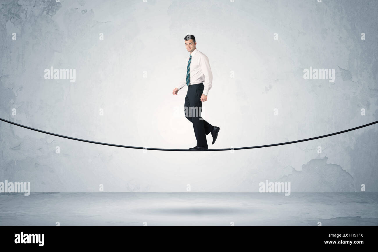 Sales guy balancing on tight rope Stock Photo - Alamy