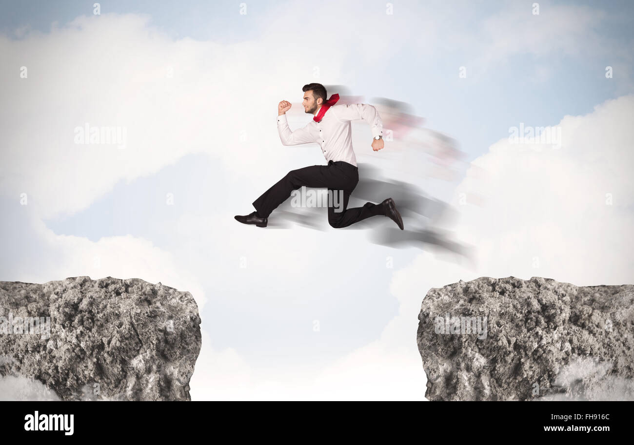 Funny business man jumping over rocks with gap Stock Photo - Alamy