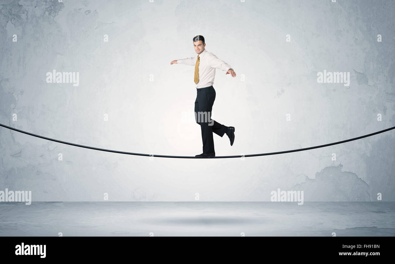 Sales guy balancing on tight rope Stock Photo - Alamy