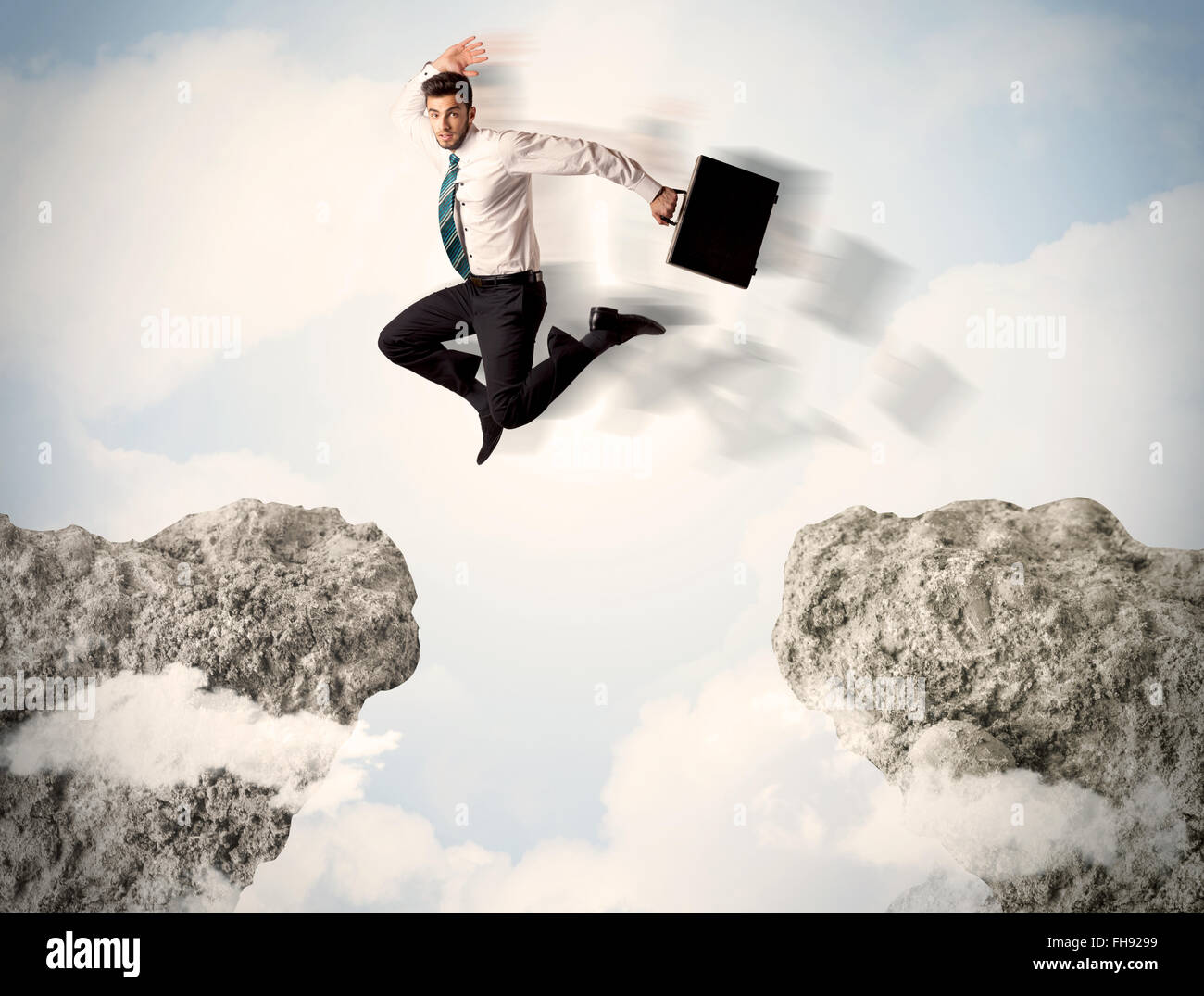 Happy business man jumping over a cliff Stock Photo - Alamy