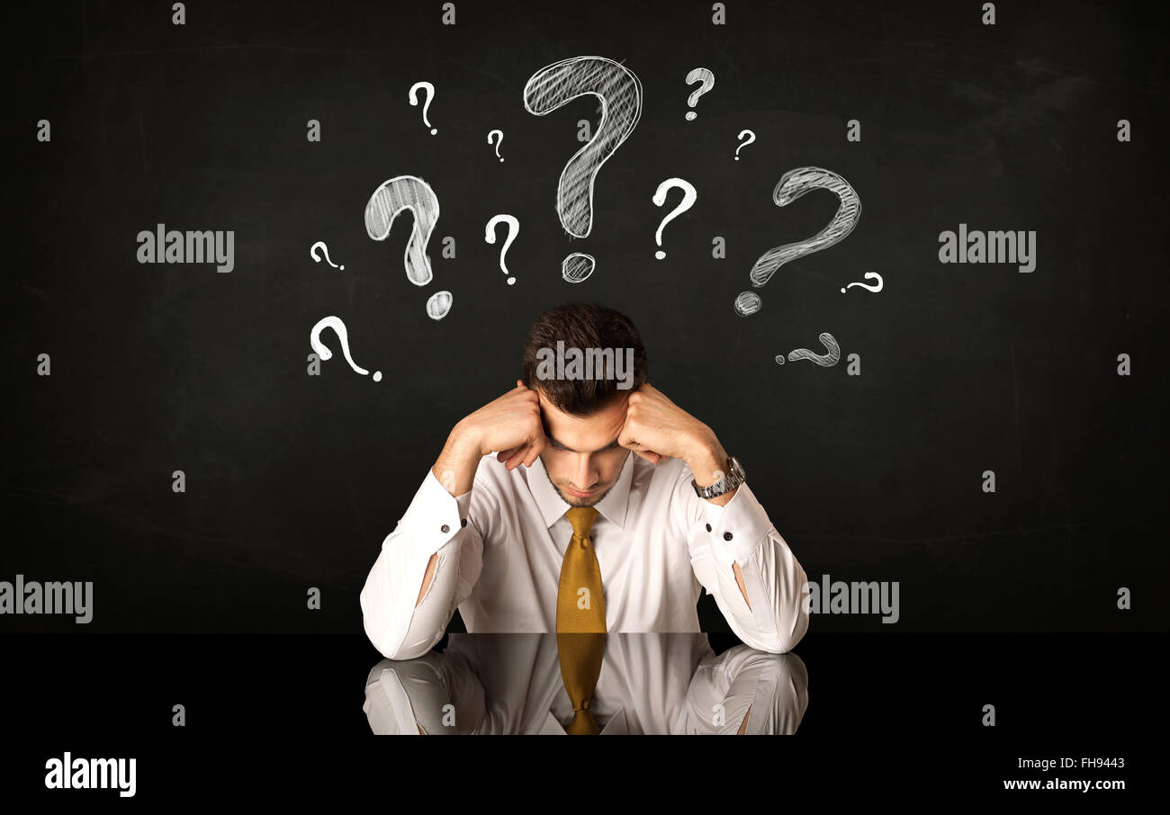 Sitting businessman under question marks Stock Photo - Alamy