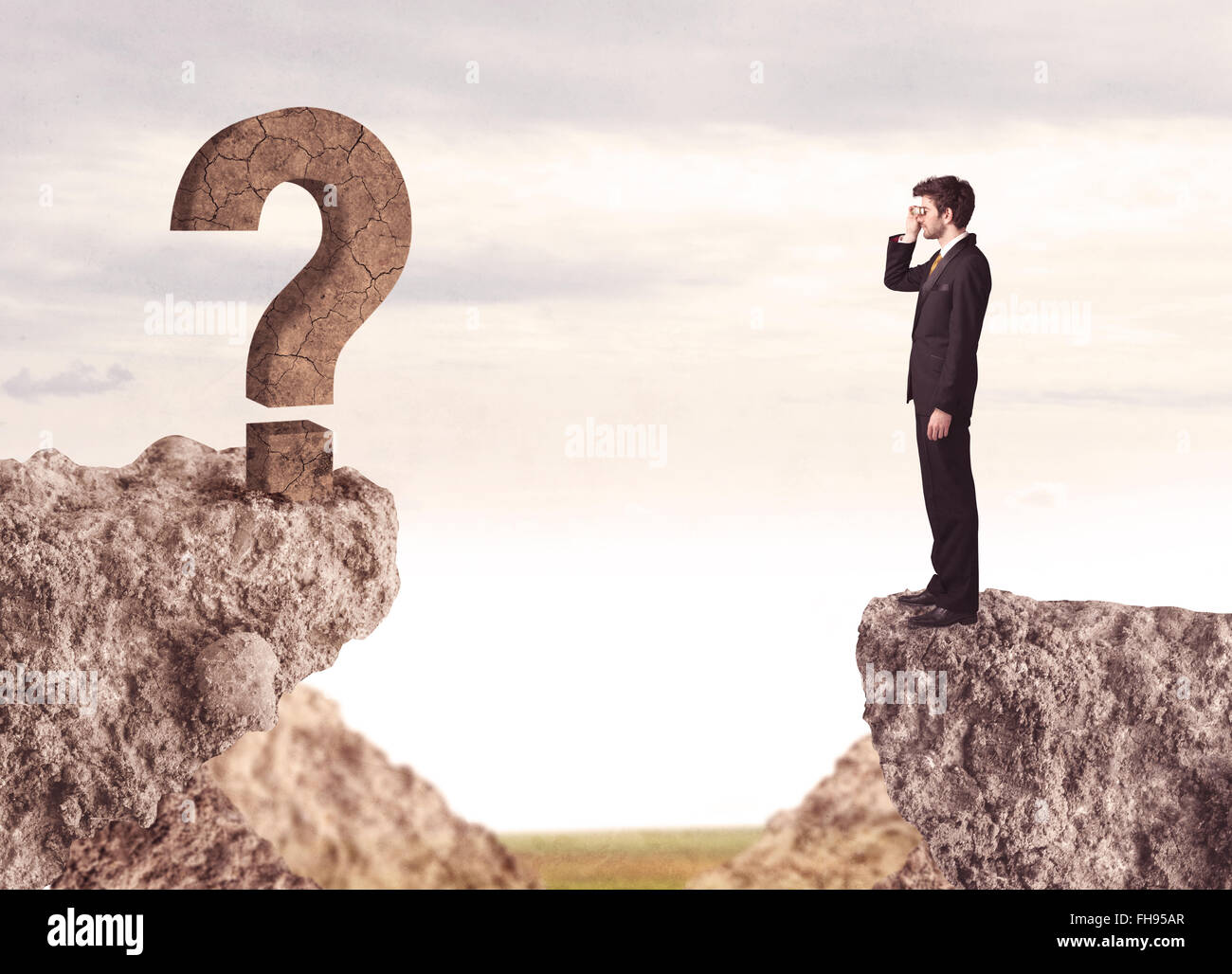 Businessman on rock mountain with a question mark Stock Photo - Alamy