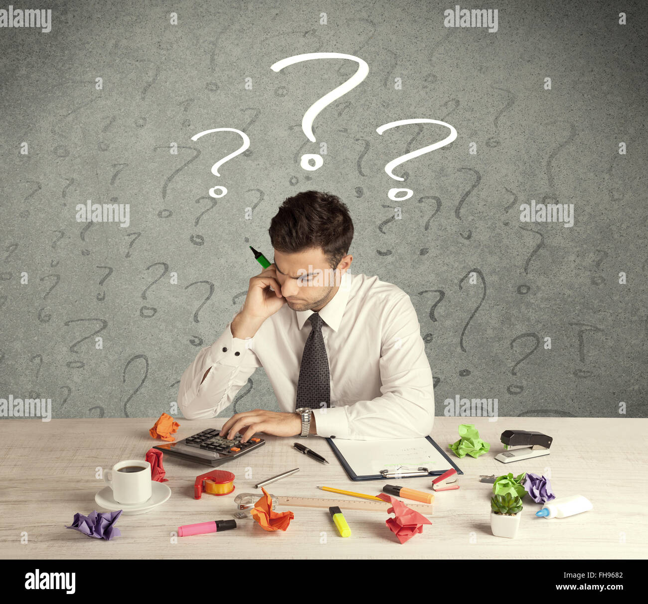 Businessman at desk with question mark Stock Photo - Alamy