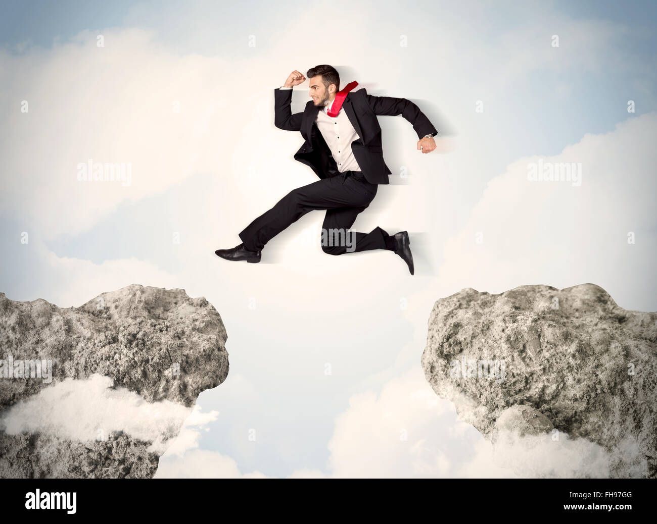 Happy business man jumping over a cliff Stock Photo - Alamy