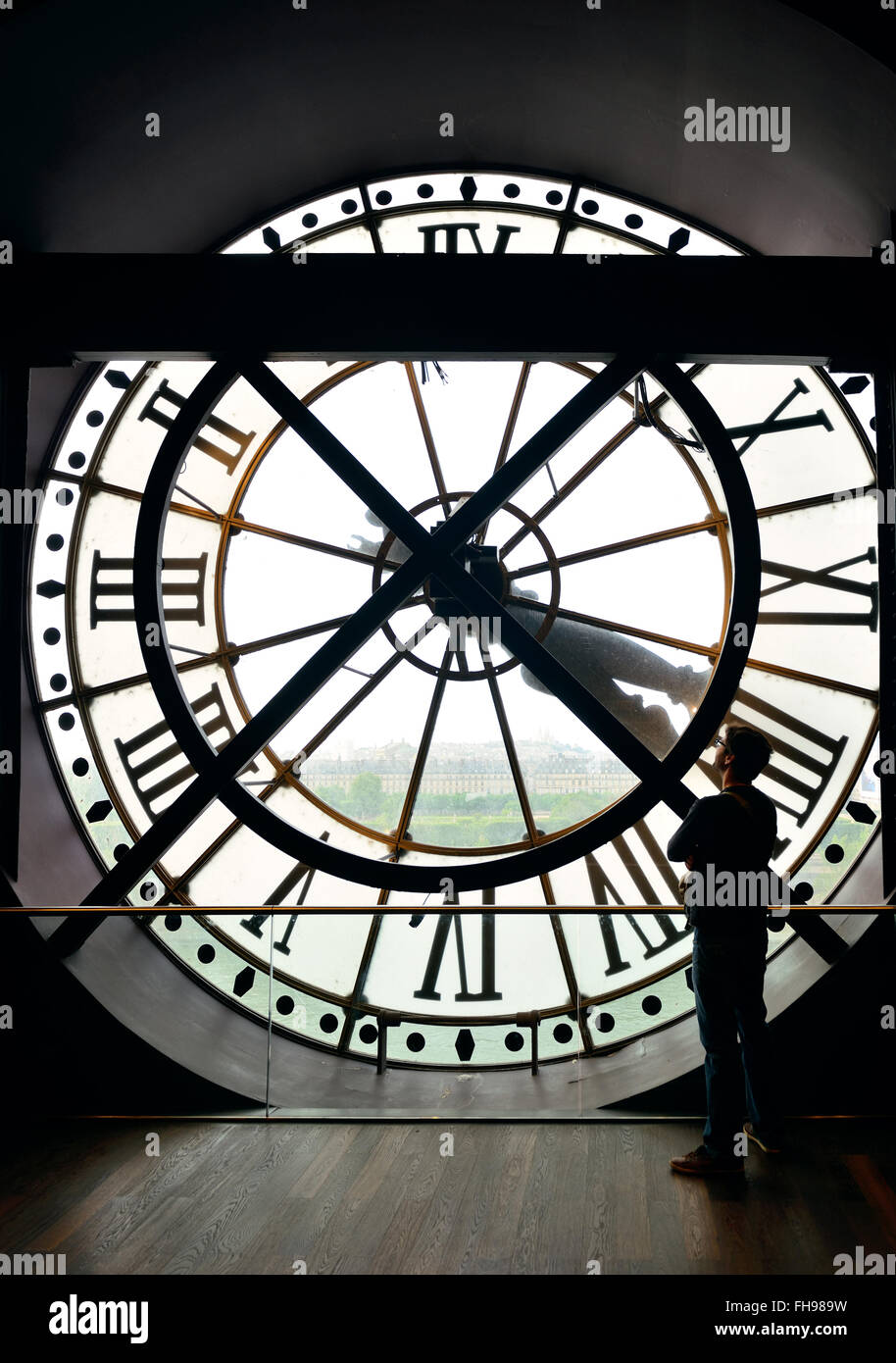 A tourist looking thrugh giant clock tower in Paris, France Stock Photo ...