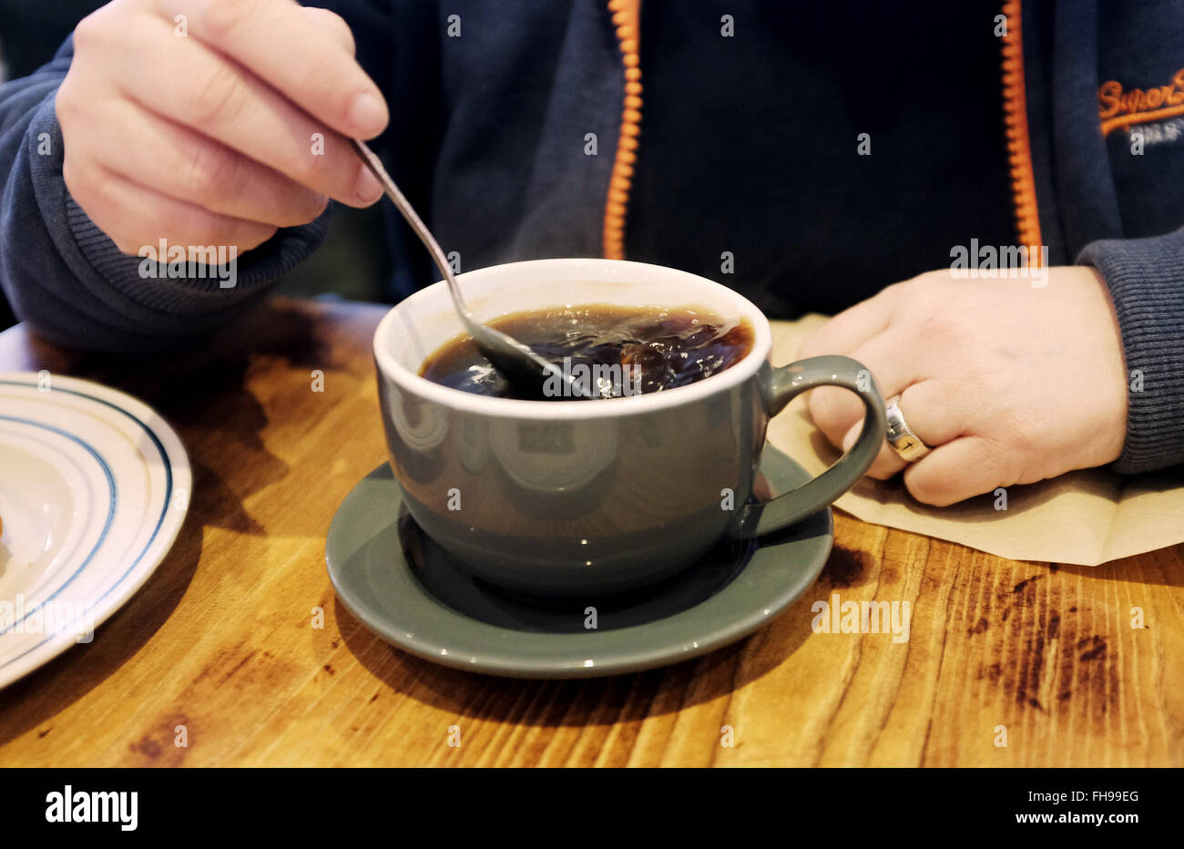 Stirring sugar cubes into a cup of black coffee Stock Photo - Alamy