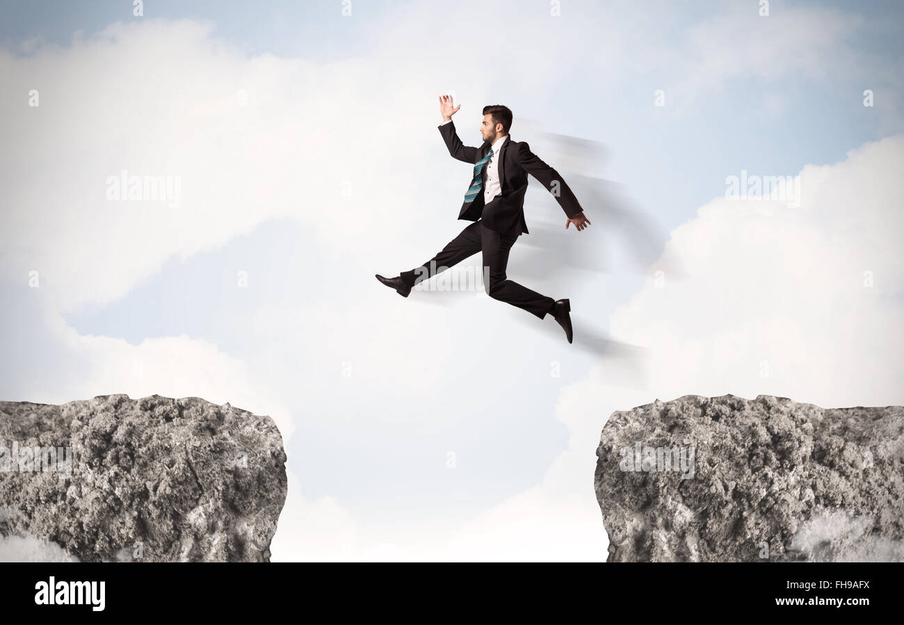 Funny business man jumping over rocks with gap Stock Photo - Alamy