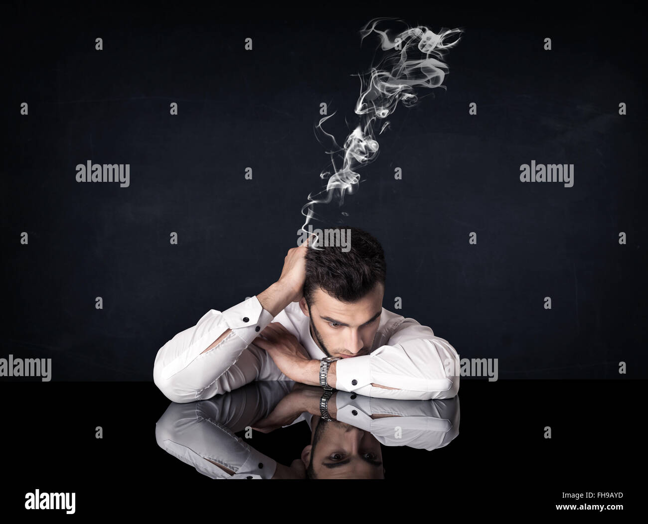 Depressed businessman with smoking head Stock Photo - Alamy