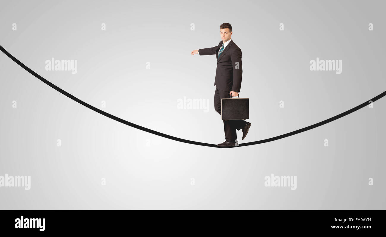 Happy businessman walking on rope Stock Photo - Alamy