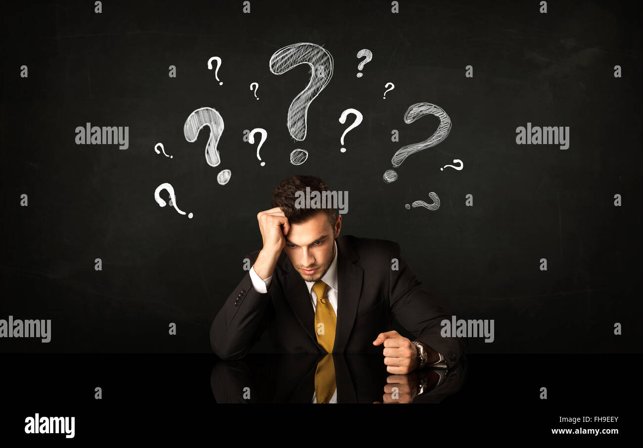 Sitting businessman under question marks Stock Photo - Alamy