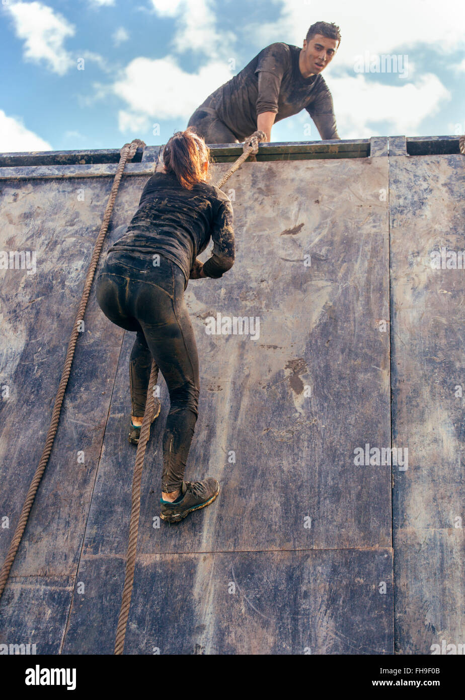 Participants in extreme obstacle race climbing wall Stock Photo - Alamy